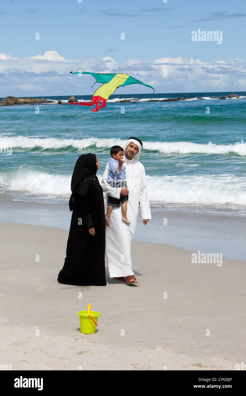 Arab family at the beach, son playing with kite Stock Photo - Alamy