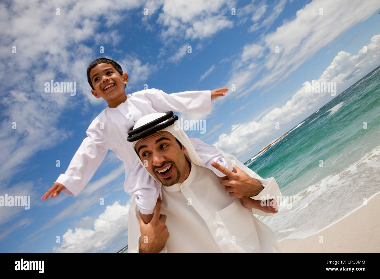 Arab father carrying his son on shoulders at the beach Stock Photo - Alamy