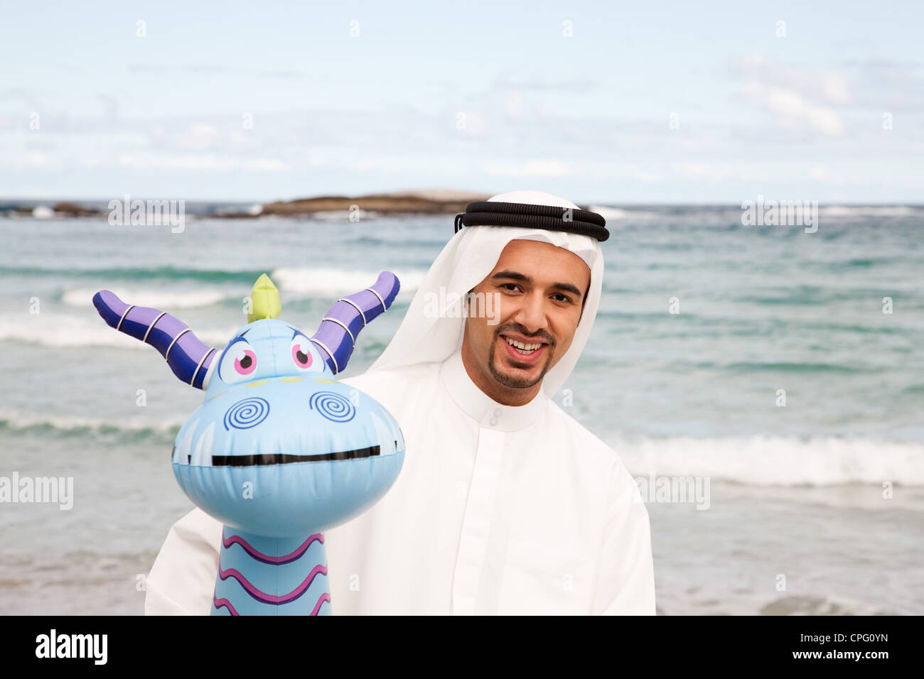 Young arab man with inflatable standing at the beach, smiling Stock ...