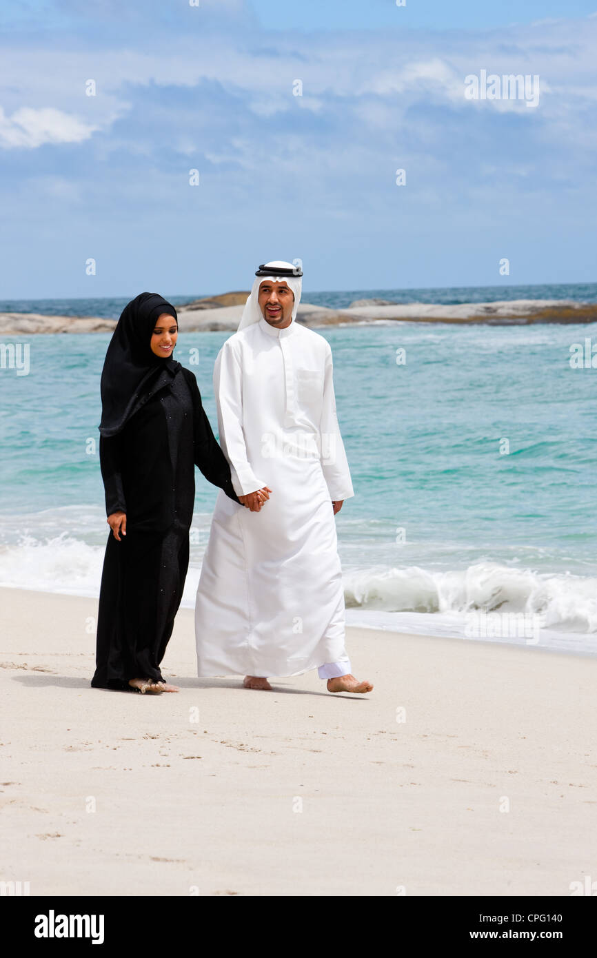 Young arab couple walking at the beach Stock Photo - Alamy
