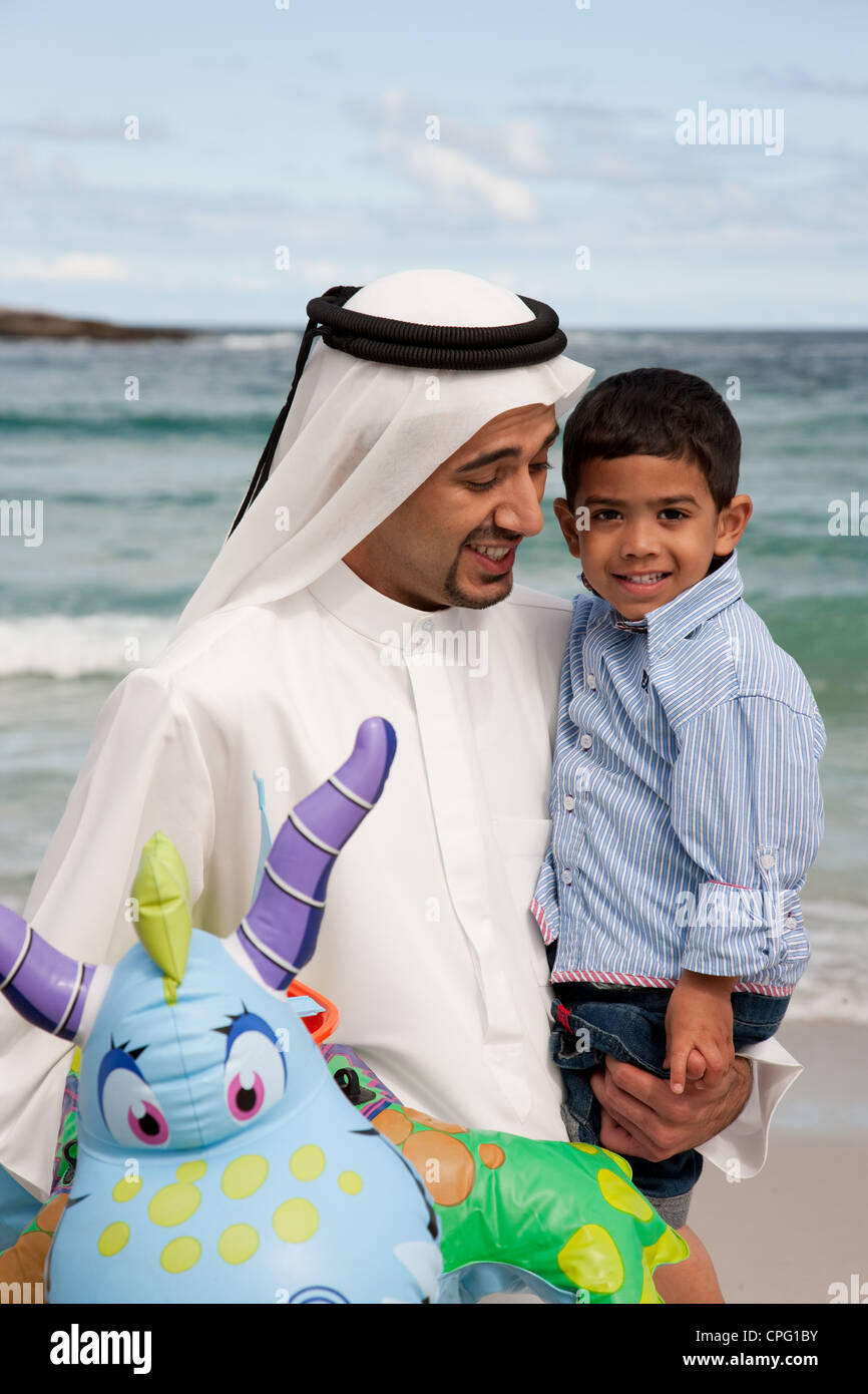 Arab father and son at the beach, smiling Stock Photo - Alamy