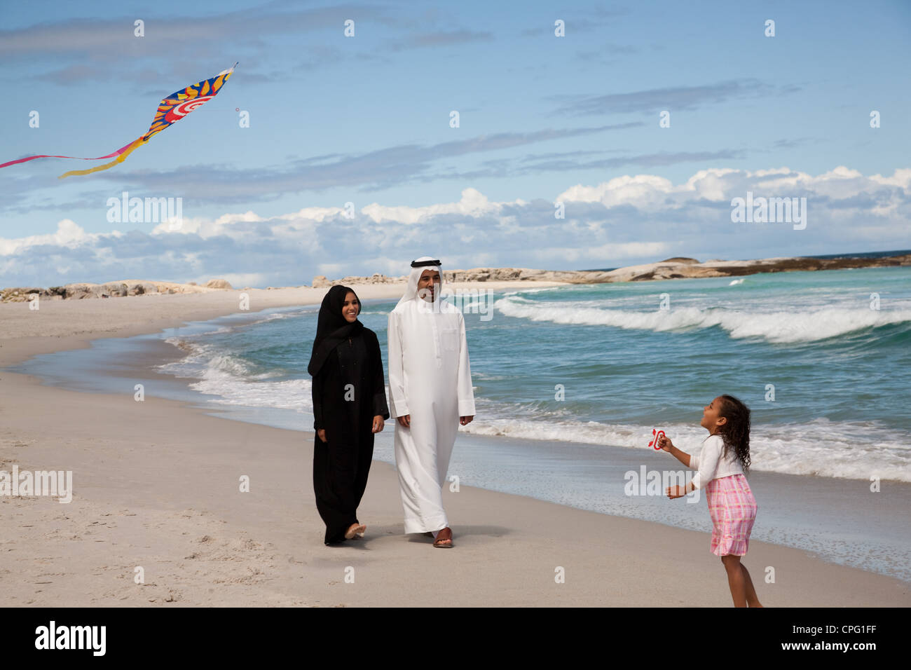 Arab family at the beach, daughter playing with kite Stock Photo - Alamy