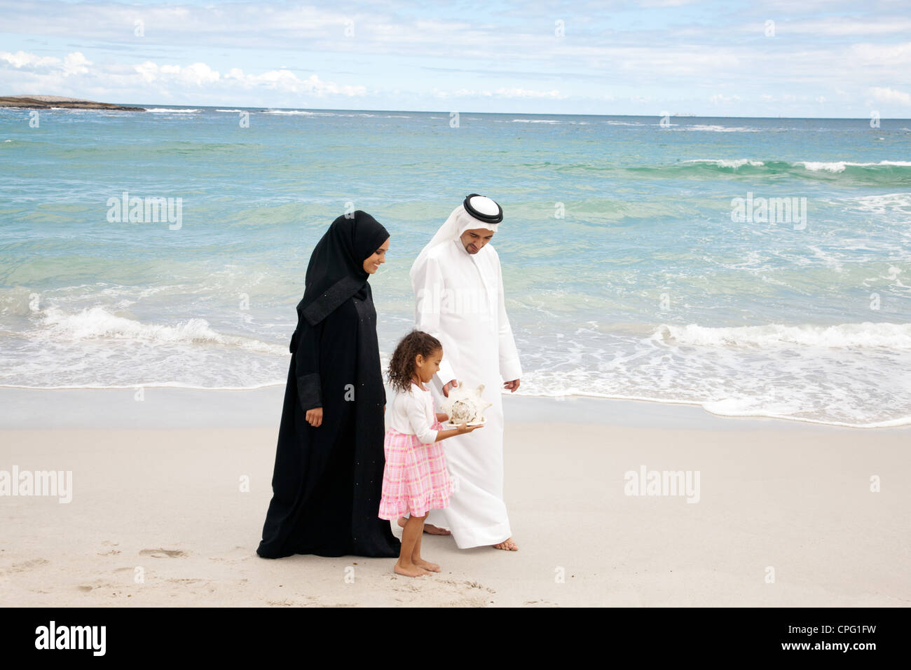 Arab family at the beach, daughter holding a seashell Stock Photo - Alamy