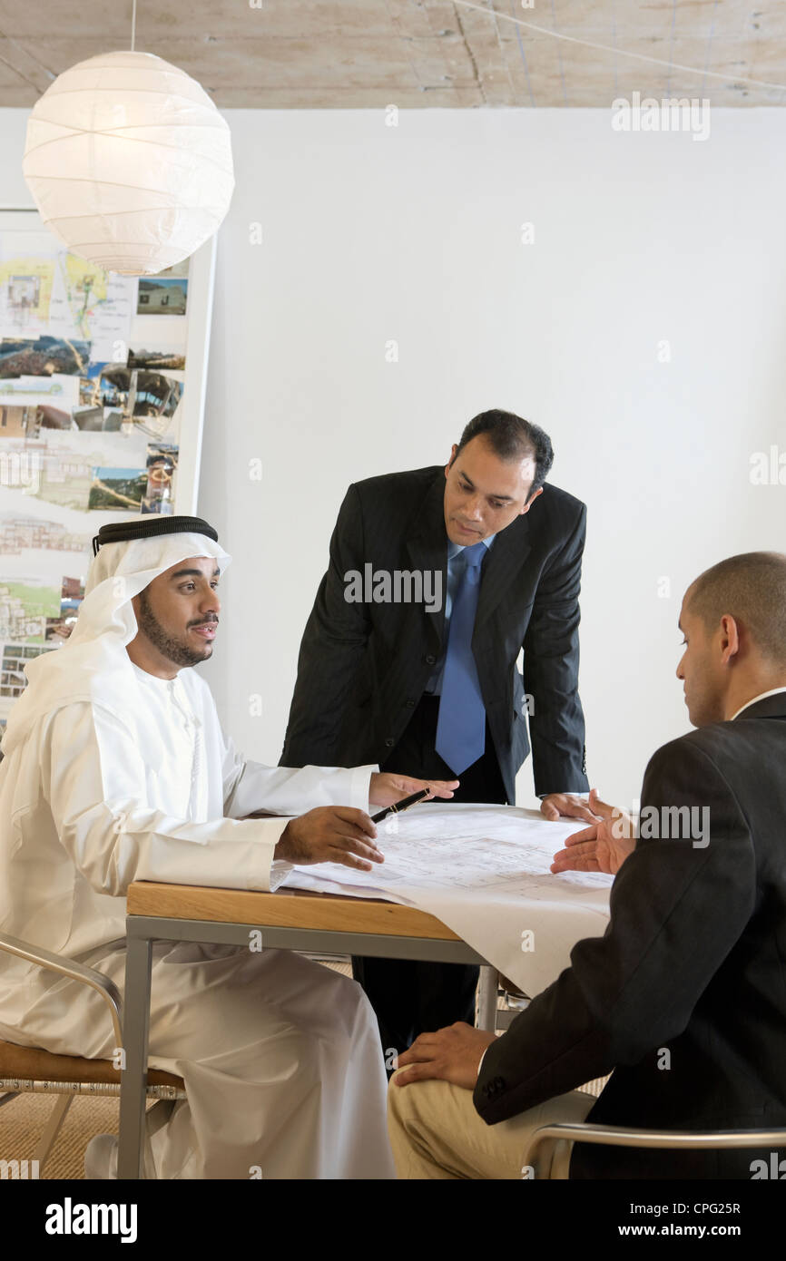 Three businessmen discussing over blueprint Stock Photo - Alamy