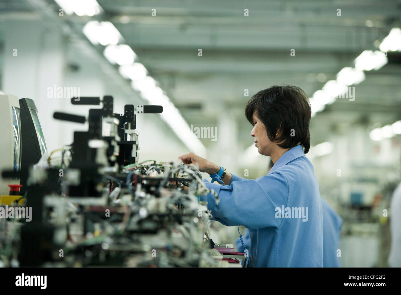 A worker assembles hand-held inventory computer devices on the assembly ...