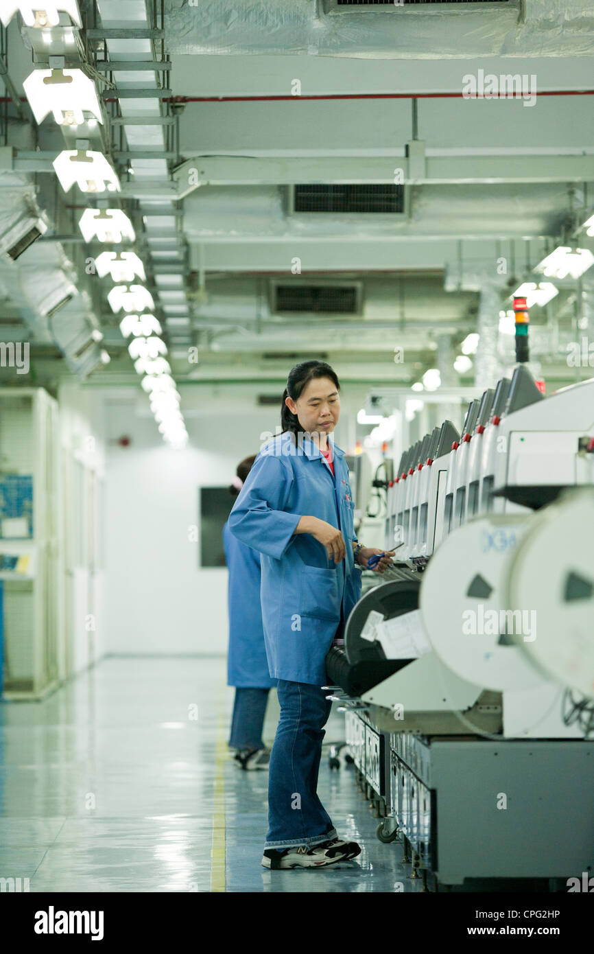 A worker checks machines on the assembly line at the Venture Corp ...