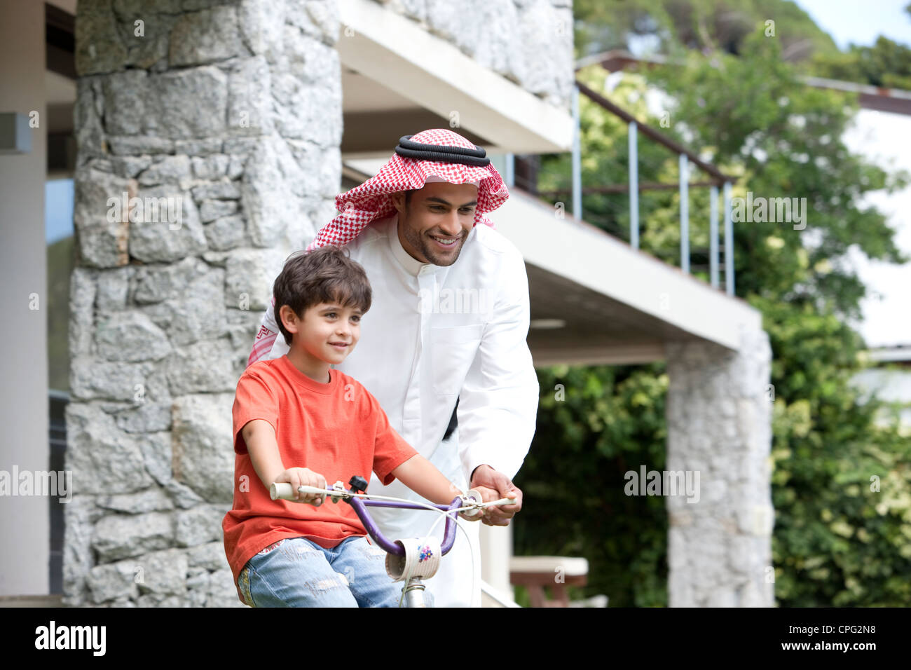 Arab father teaching his son how to ride a bicycle Stock Photo - Alamy