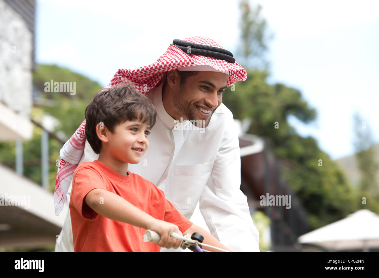 Arab father teaching his son how to ride a bicycle Stock Photo - Alamy