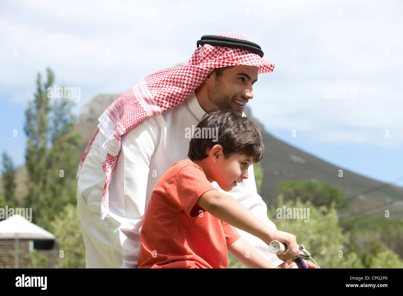 Arab father teaching his son how to ride a bicycle Stock Photo - Alamy