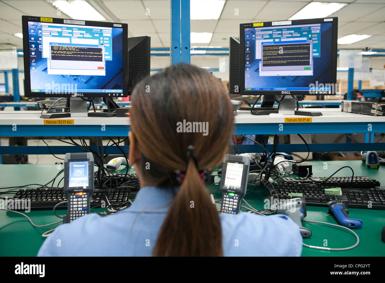 A worker tests hand-held inventory computer devices on the assembly ...