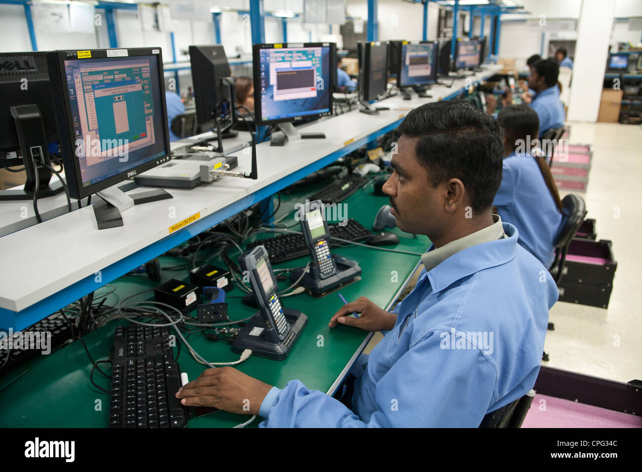 Workers test hand-held inventory computer devices on the assembly line ...