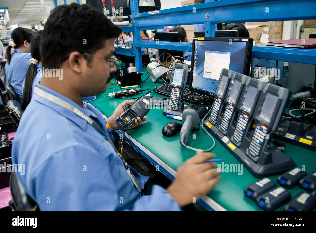 Workers test hand-held inventory computer devices on the assembly line ...