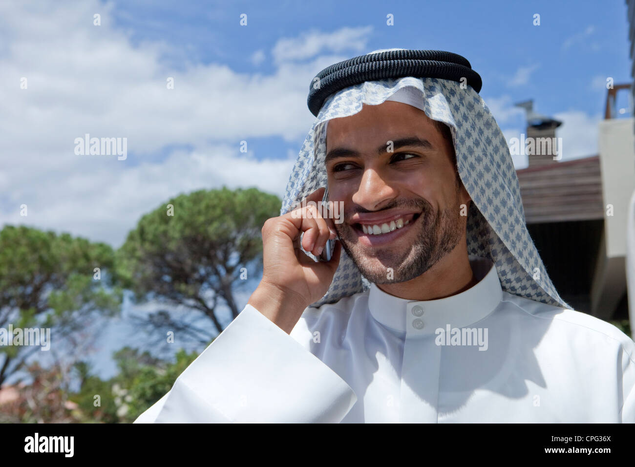 Arab man using mobile phone, standing in the balcony Stock Photo - Alamy