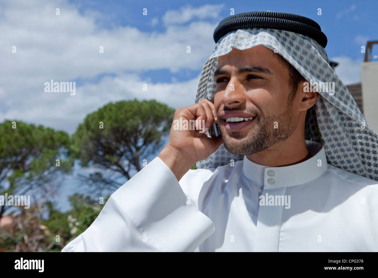 Arab man using mobile phone, standing in the balcony Stock Photo - Alamy