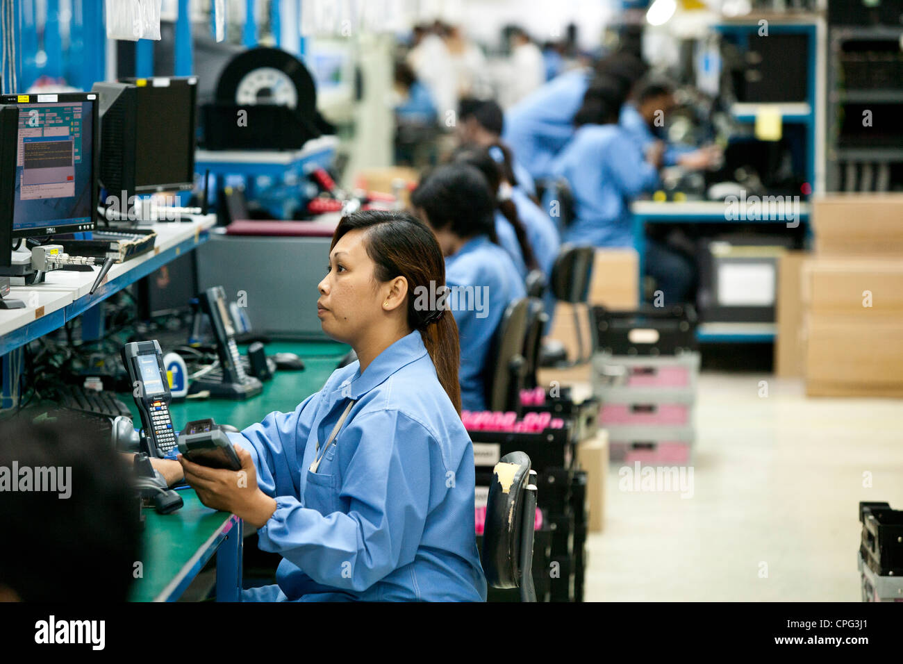 Workers assemble hand-held inventory computer devices on the assembly ...