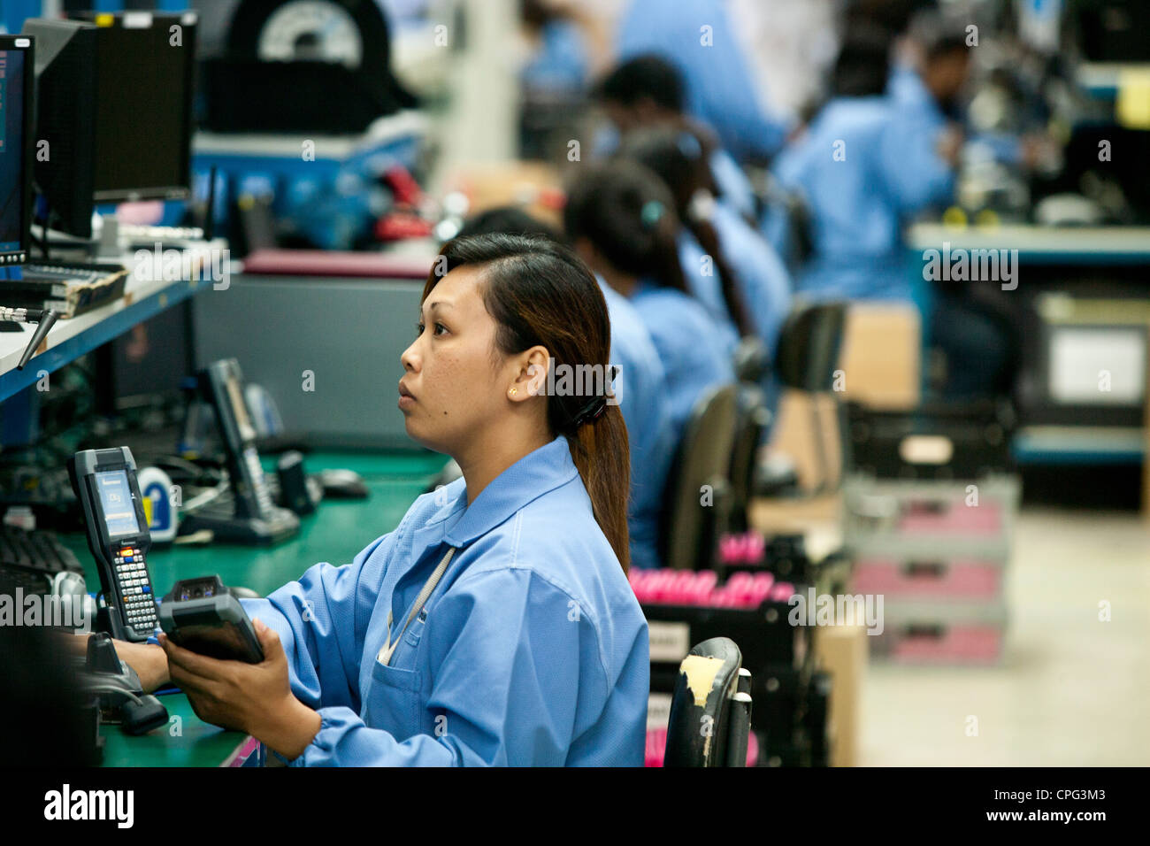 Workers assemble hand-held inventory computer devices on the assembly ...