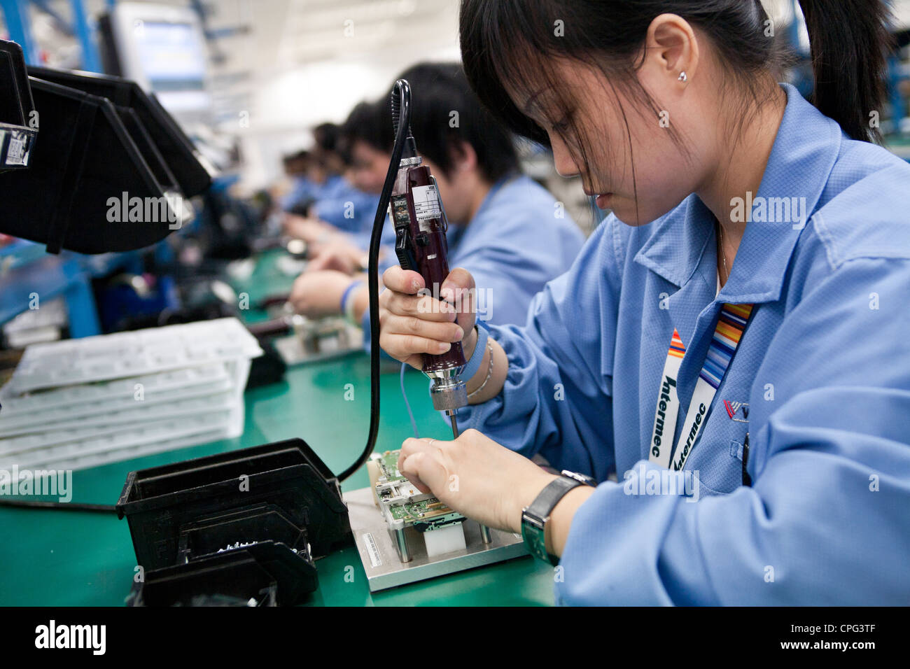 Workers assemble hand-held inventory computer devices on the assembly ...