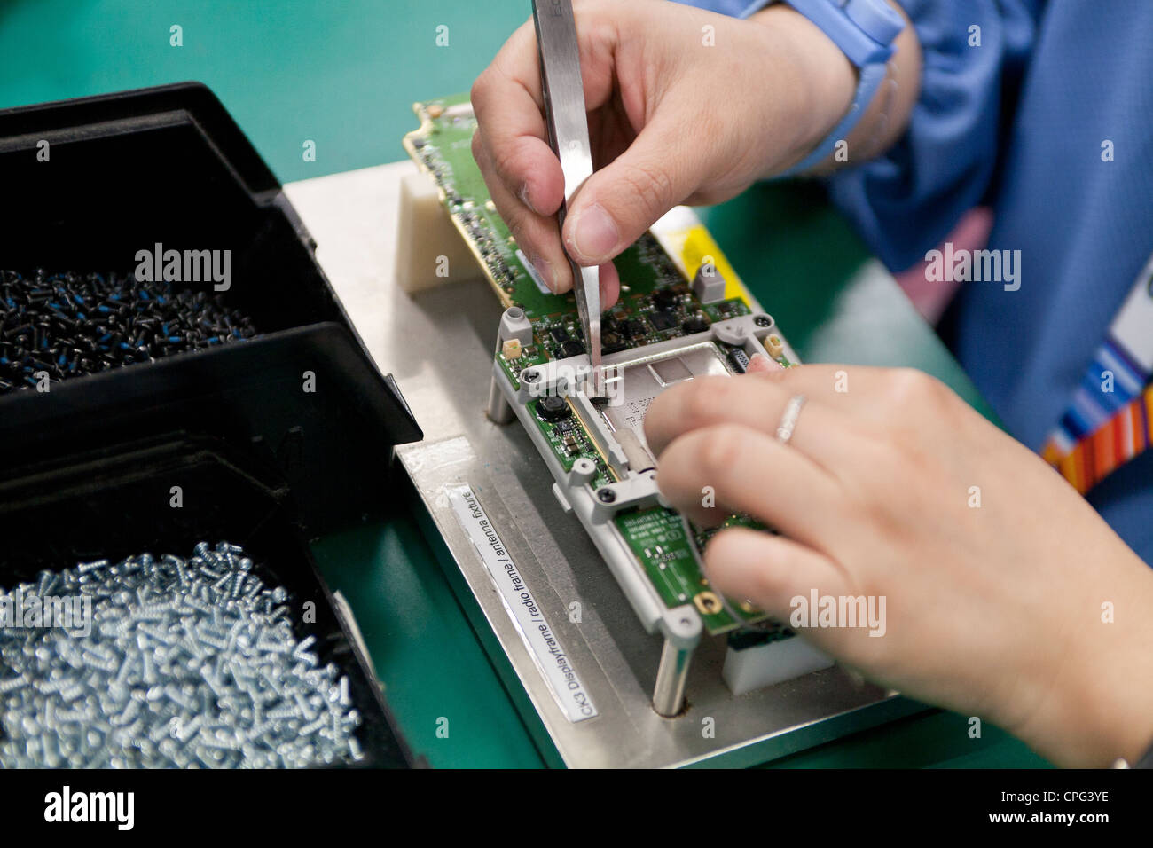 A worker assembles hand-held inventory computer devices on the assembly ...