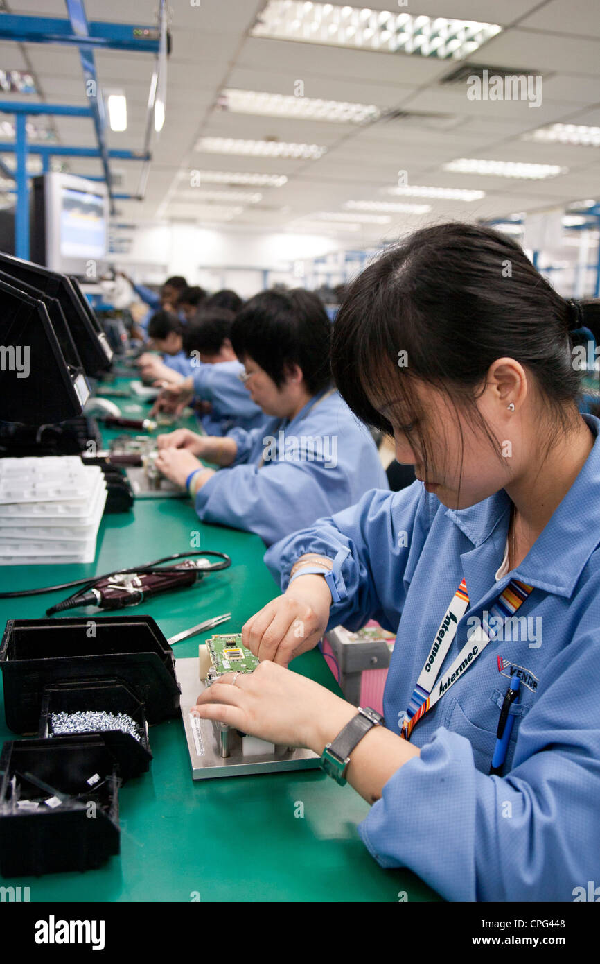 Workers assemble hand-held inventory computer devices on the assembly ...