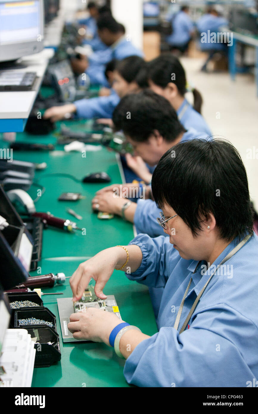 Workers assemble hand-held inventory computer devices on the assembly ...