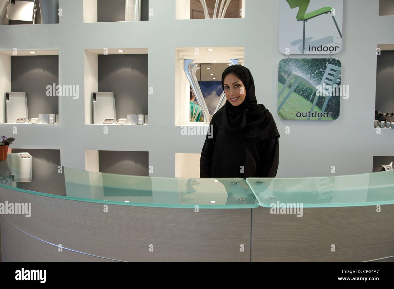 Arab receptionist standing behind counter, smiling Stock Photo - Alamy