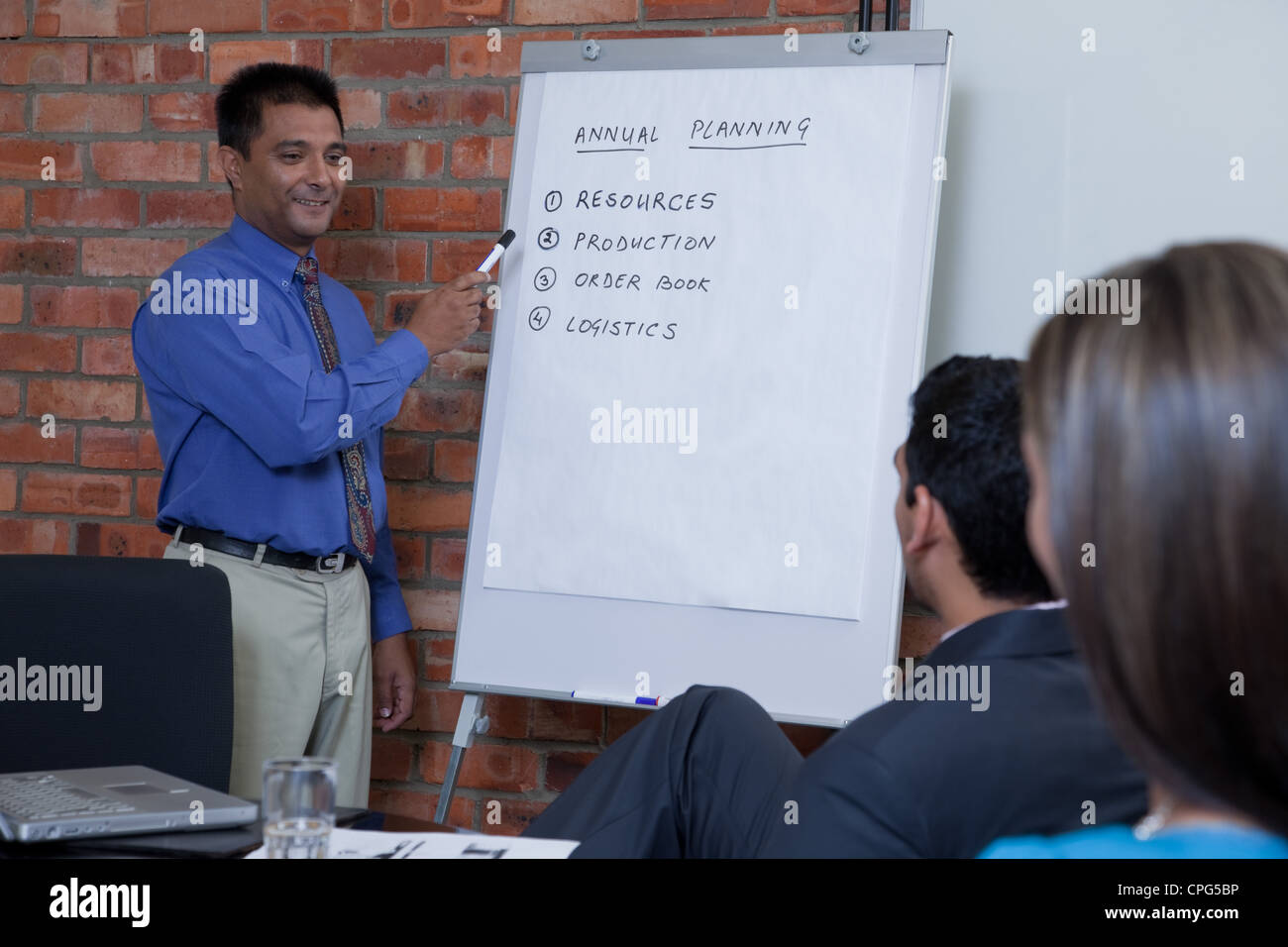 Businessman giving presentation to colleagues Stock Photo - Alamy