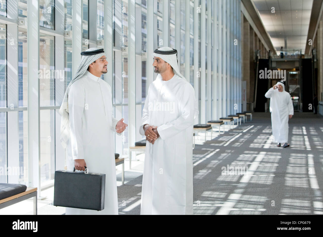 Arab businessmen talking in office hallway Stock Photo - Alamy