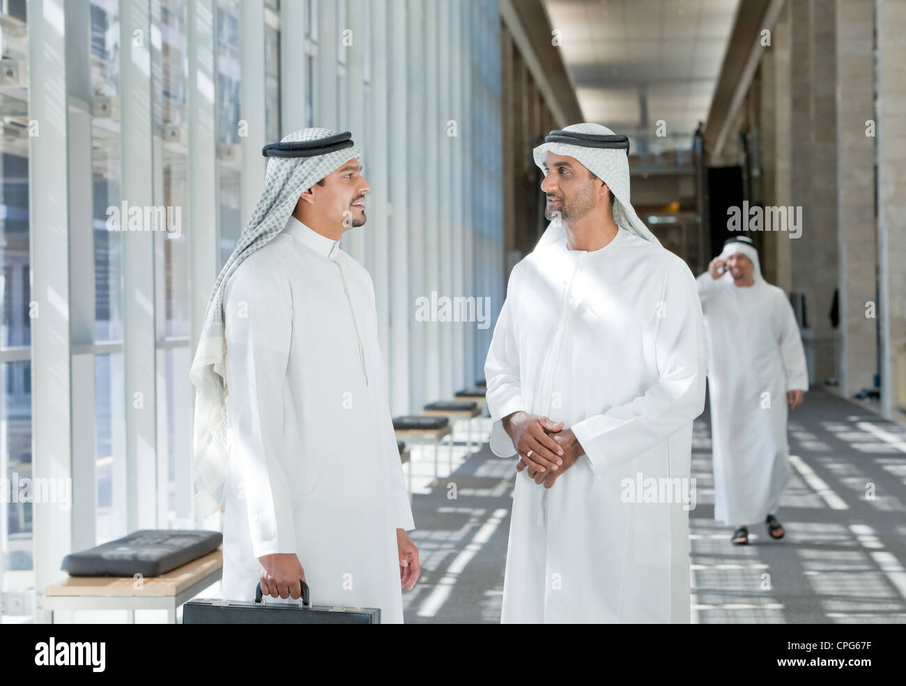 Arab businessmen talking in office hallway Stock Photo - Alamy