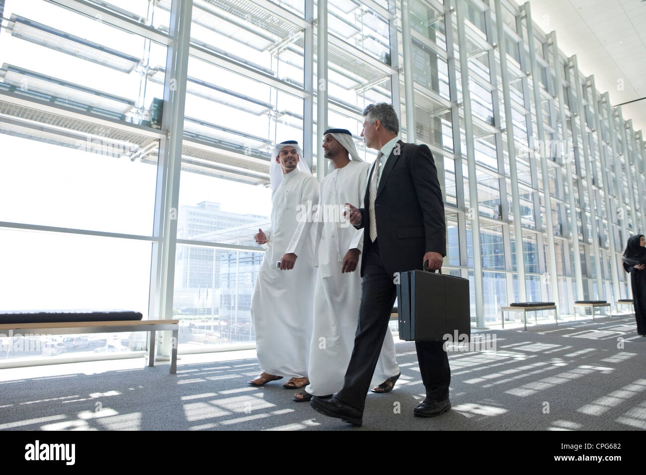 Three businessmen talking in office hallway Stock Photo - Alamy