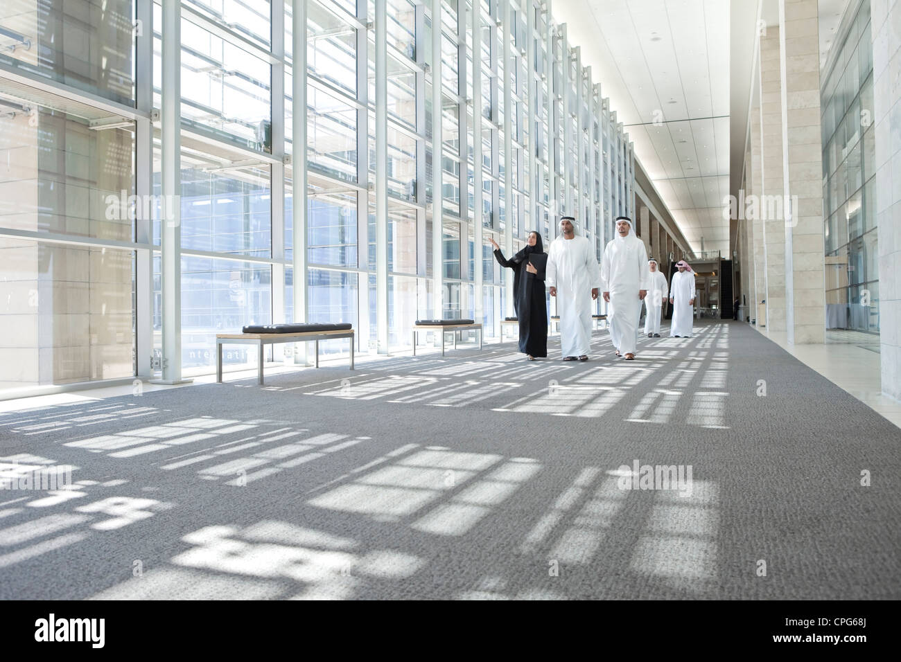 Business people talking while walking in the office hallway Stock Photo ...