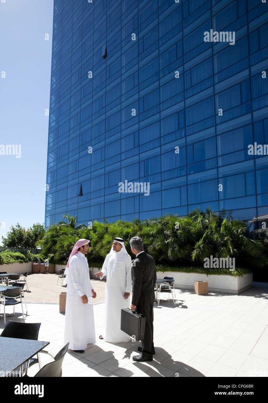 Three businessmen talking in front of office building Stock Photo - Alamy