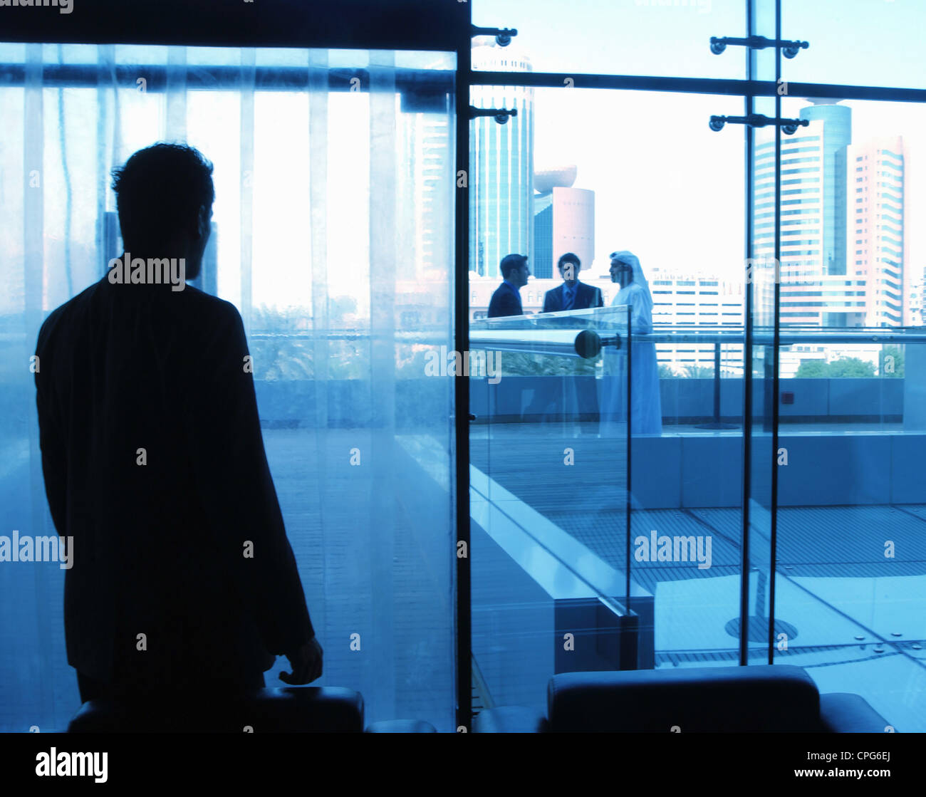 A Businessman looking on his fellow colleague from the glass door Stock ...