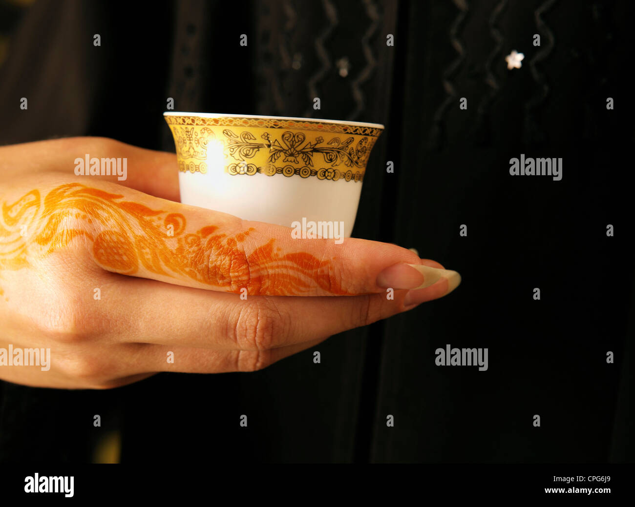 Arab lady henna on hands holding Arabic Coffee cup Stock Photo - Alamy