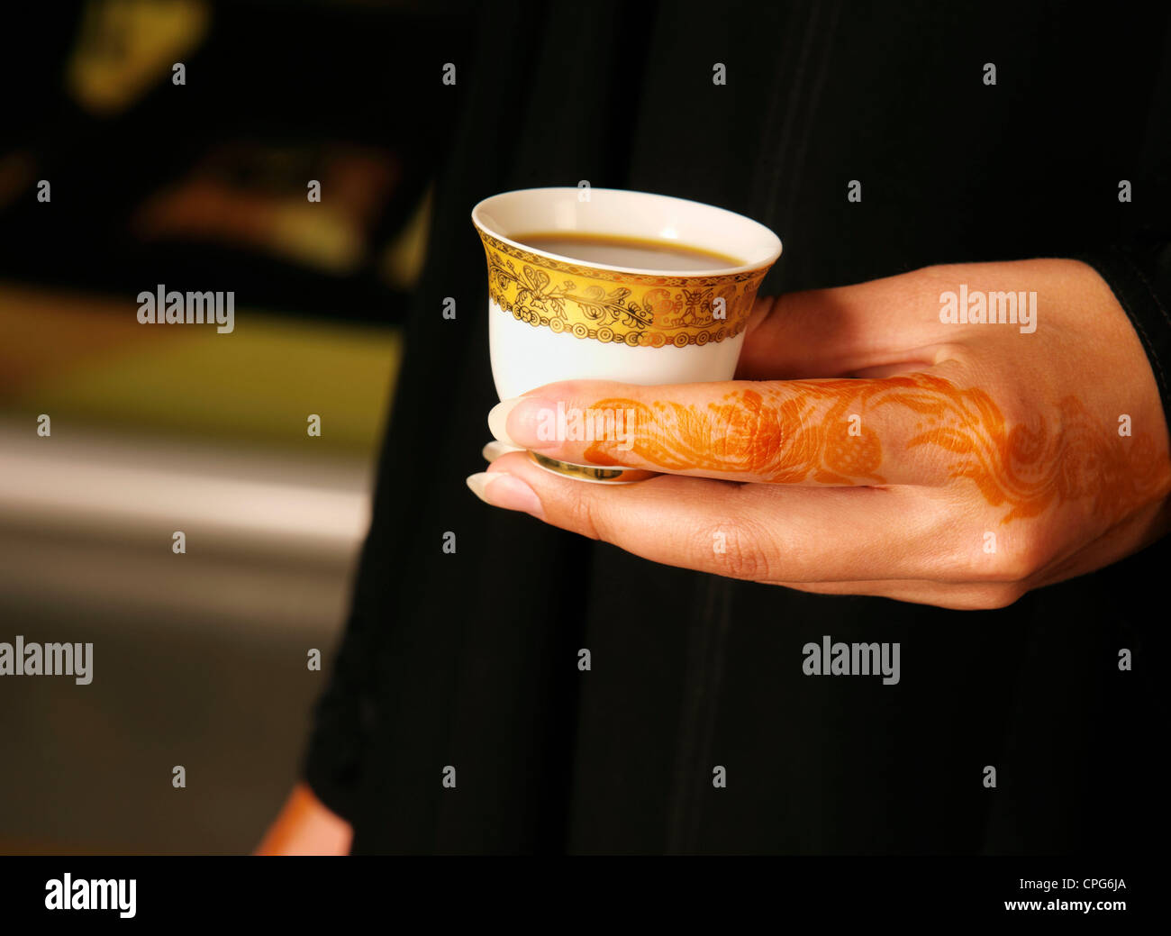 Arab lady with henna on hands holding Arabic Coffee cup Stock Photo - Alamy