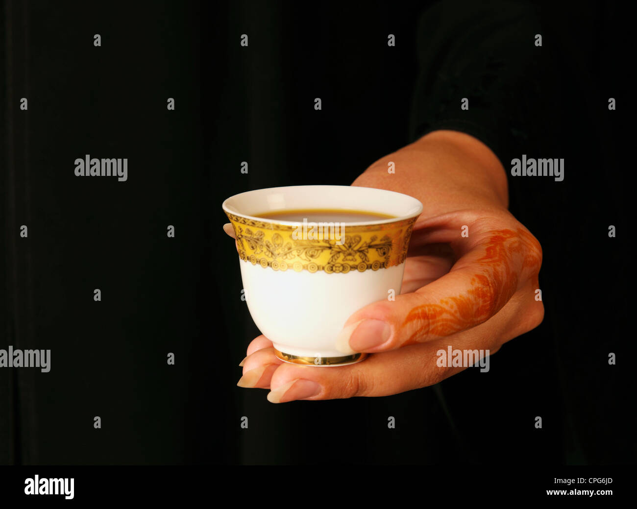 Arab lady with henna on hands holding Arabic Coffee cup Stock Photo - Alamy