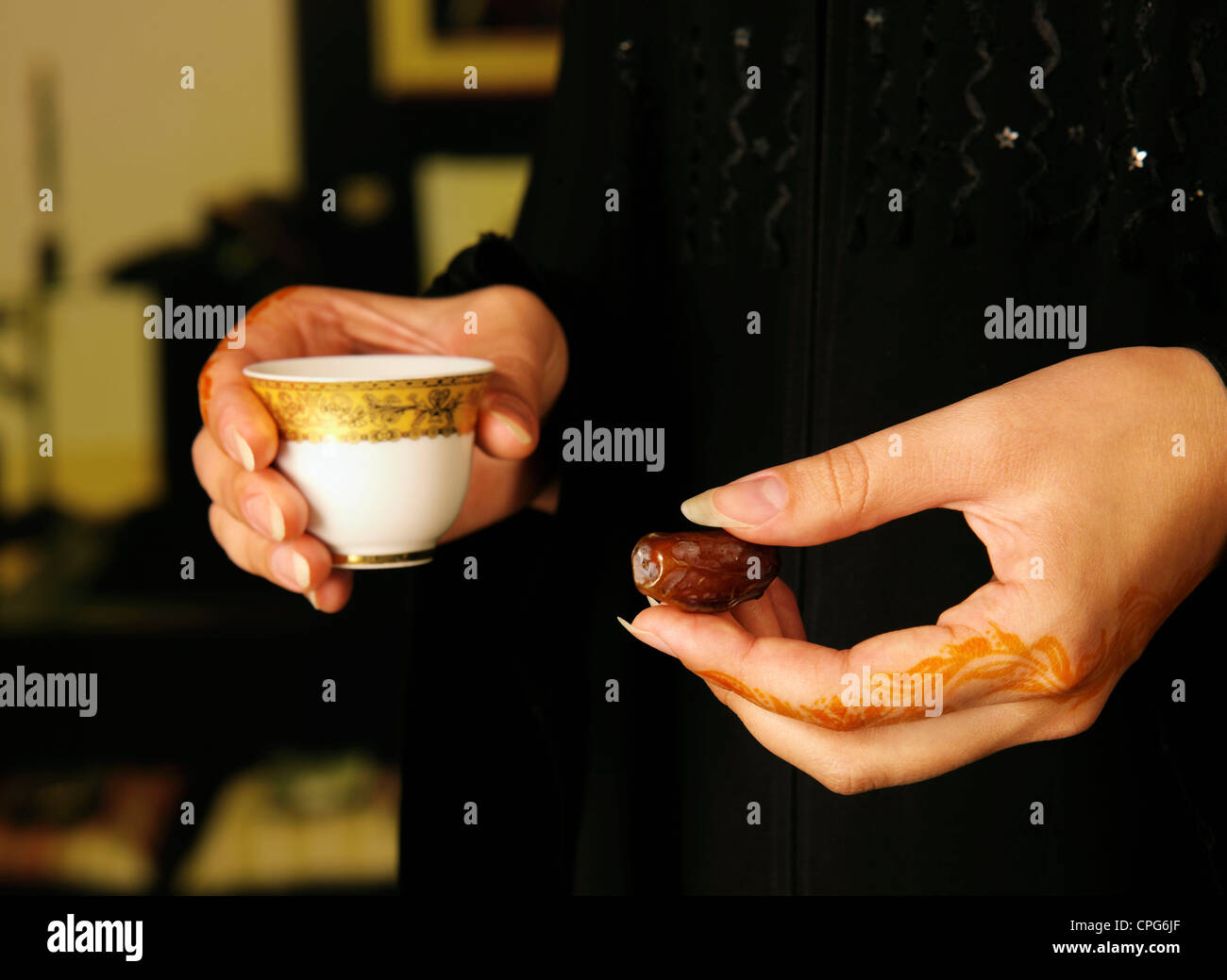 Arab lady with henna on hands holding coffee and dates Stock Photo - Alamy