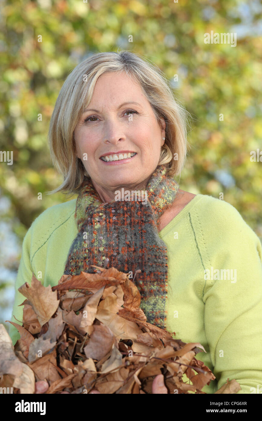 Woman with an armful of autumnal leaves Stock Photo - Alamy