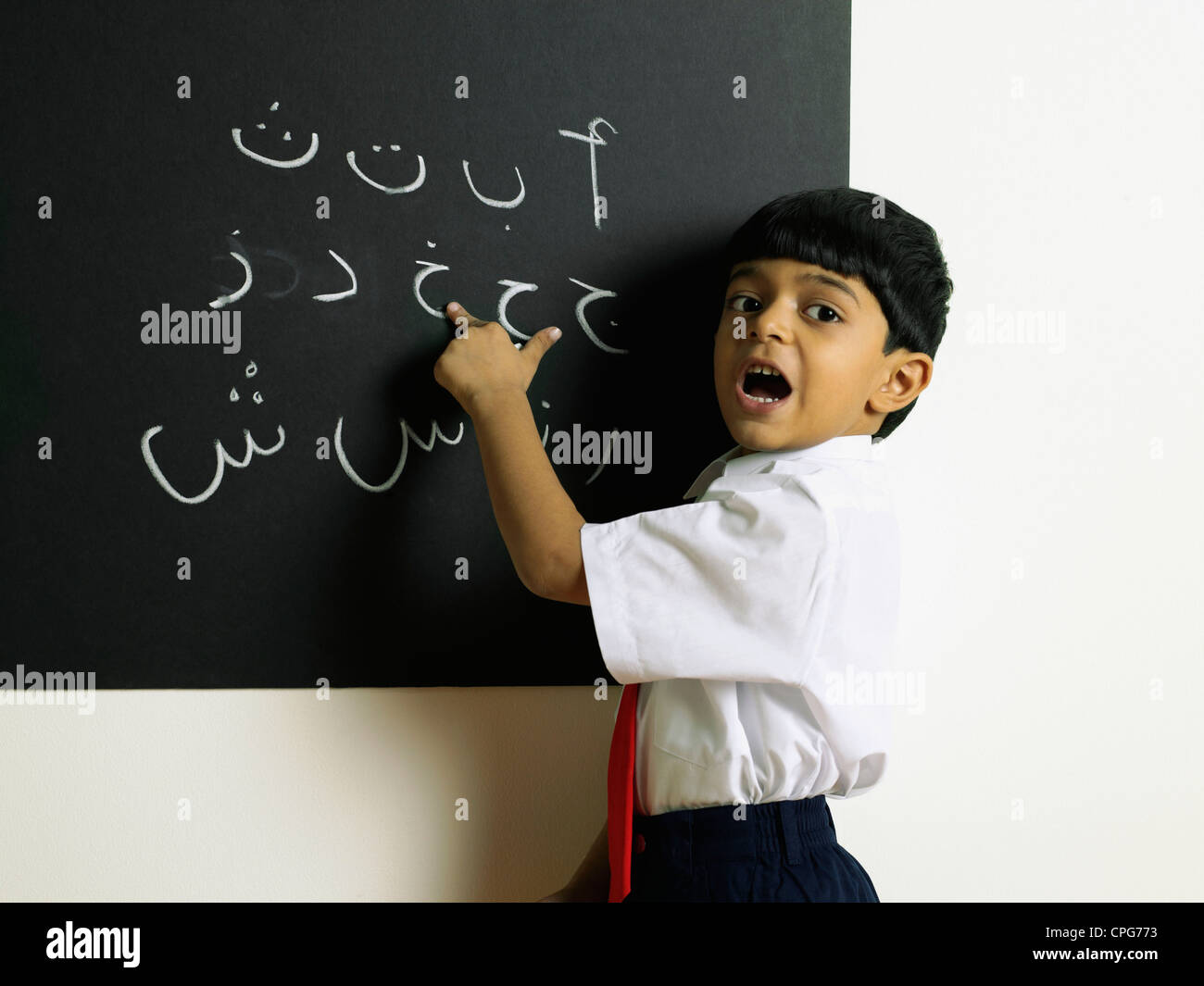 Boy reading Arabic letters on the black board Stock Photo - Alamy
