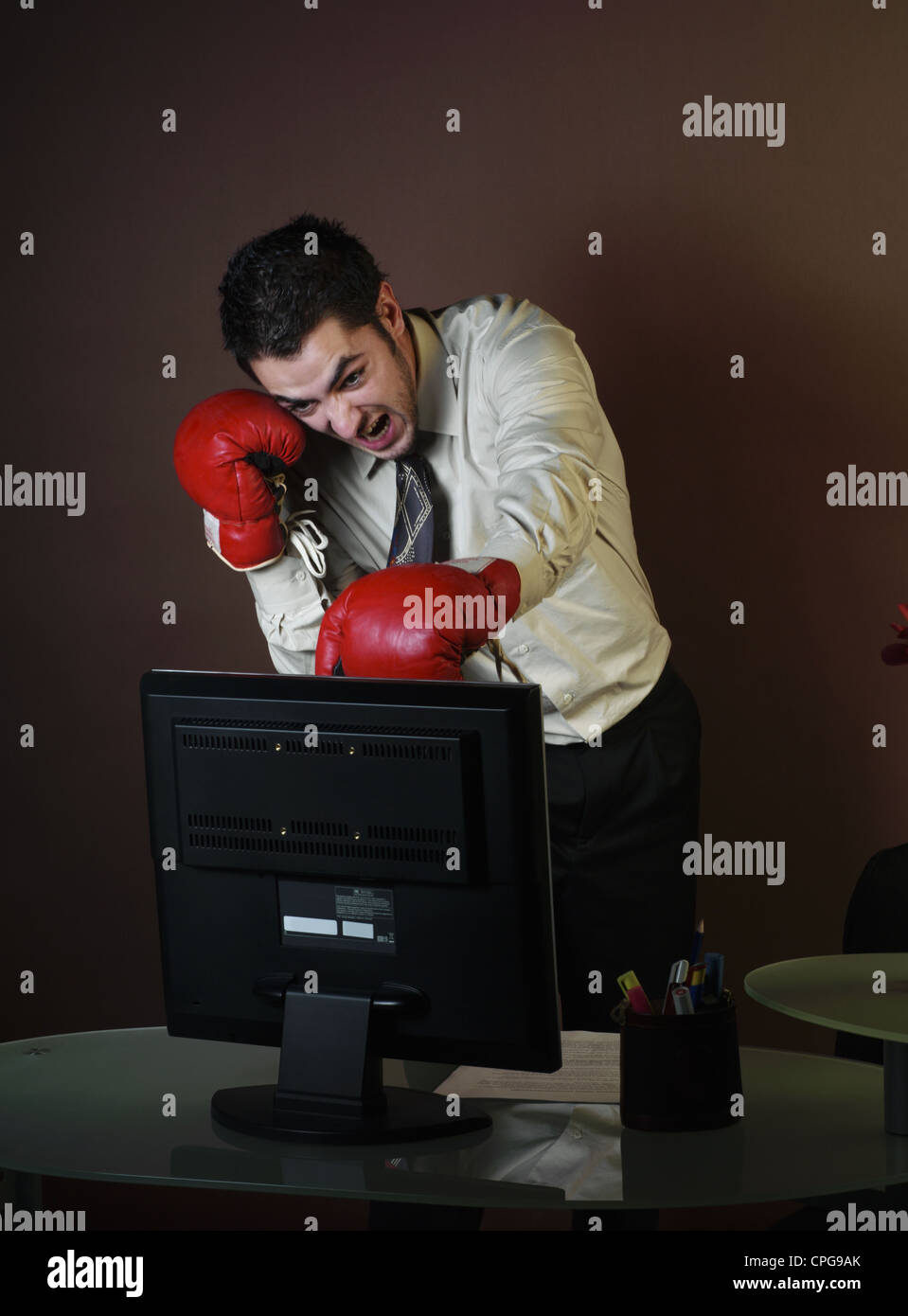 Young Businessman with boxing gloves attacking computer Stock Photo - Alamy