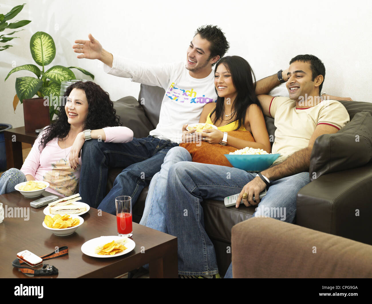 Young people watching television Stock Photo - Alamy