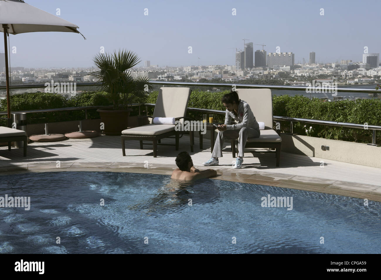 Young lady looking at man in a swimming pool Stock Photo - Alamy