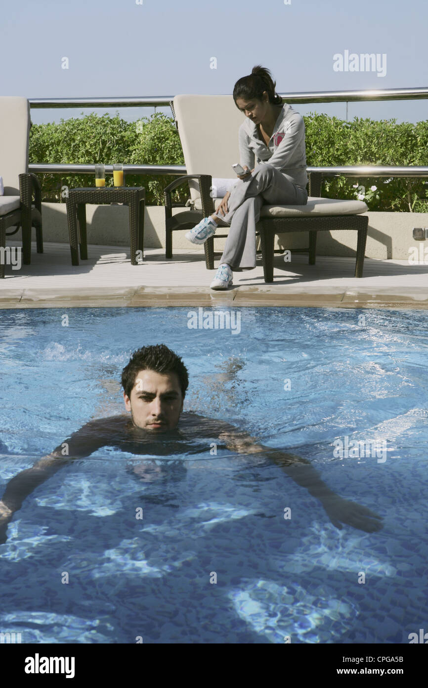 Young lady looking at man in a swimming pool Stock Photo - Alamy