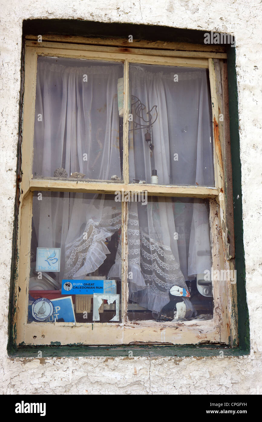 Window of an empty house with stickers on the glass and things left on ...