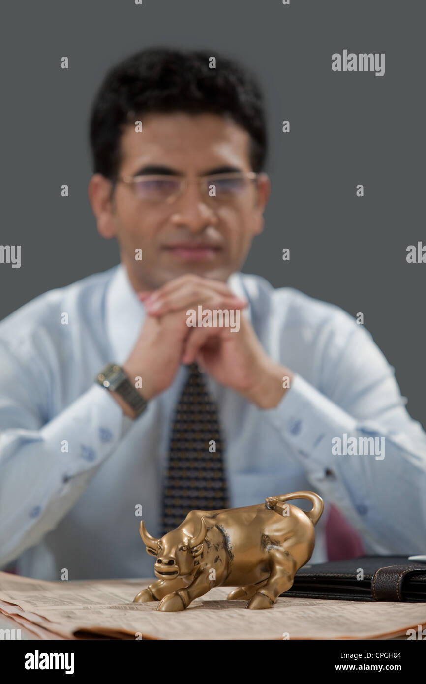 Man looking at the bull figurine on top of the table Stock Photo - Alamy