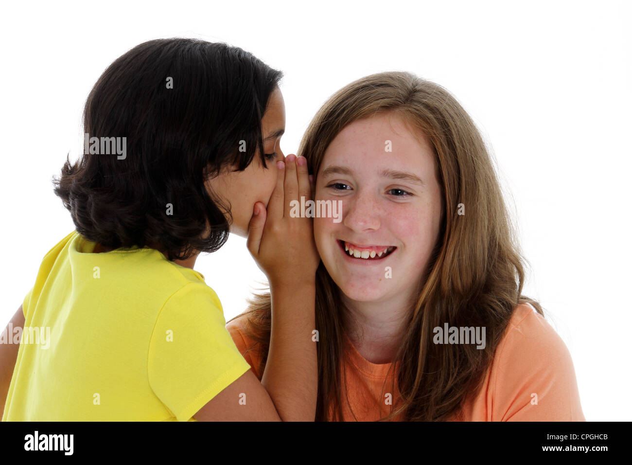 Girls telling each other a secret on white background Stock Photo - Alamy