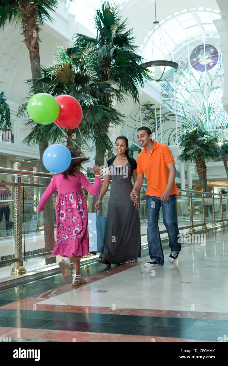 Family in the shopping mall, girl running with balloons Stock Photo - Alamy