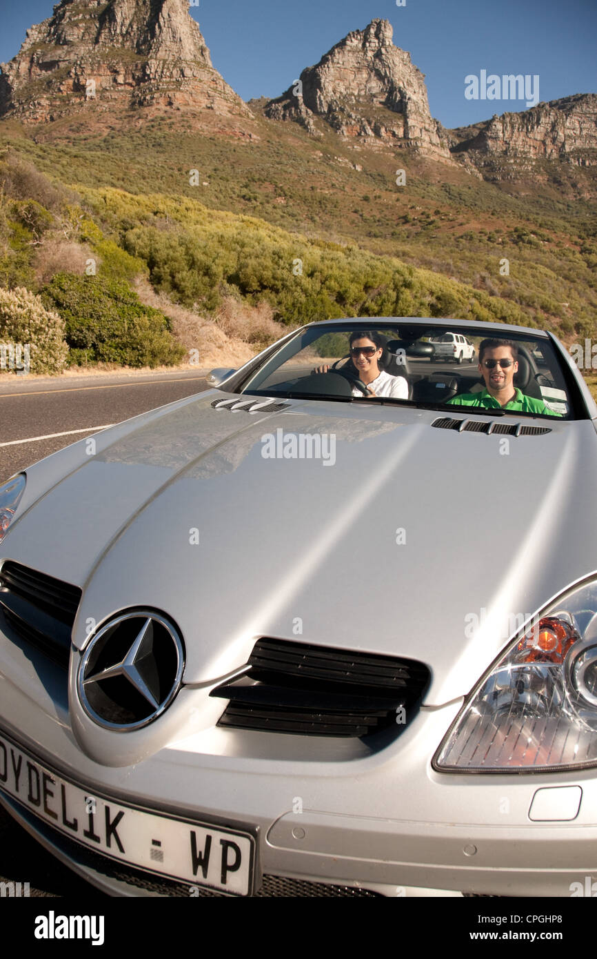 Couple riding in a convertible car, smiling Stock Photo - Alamy