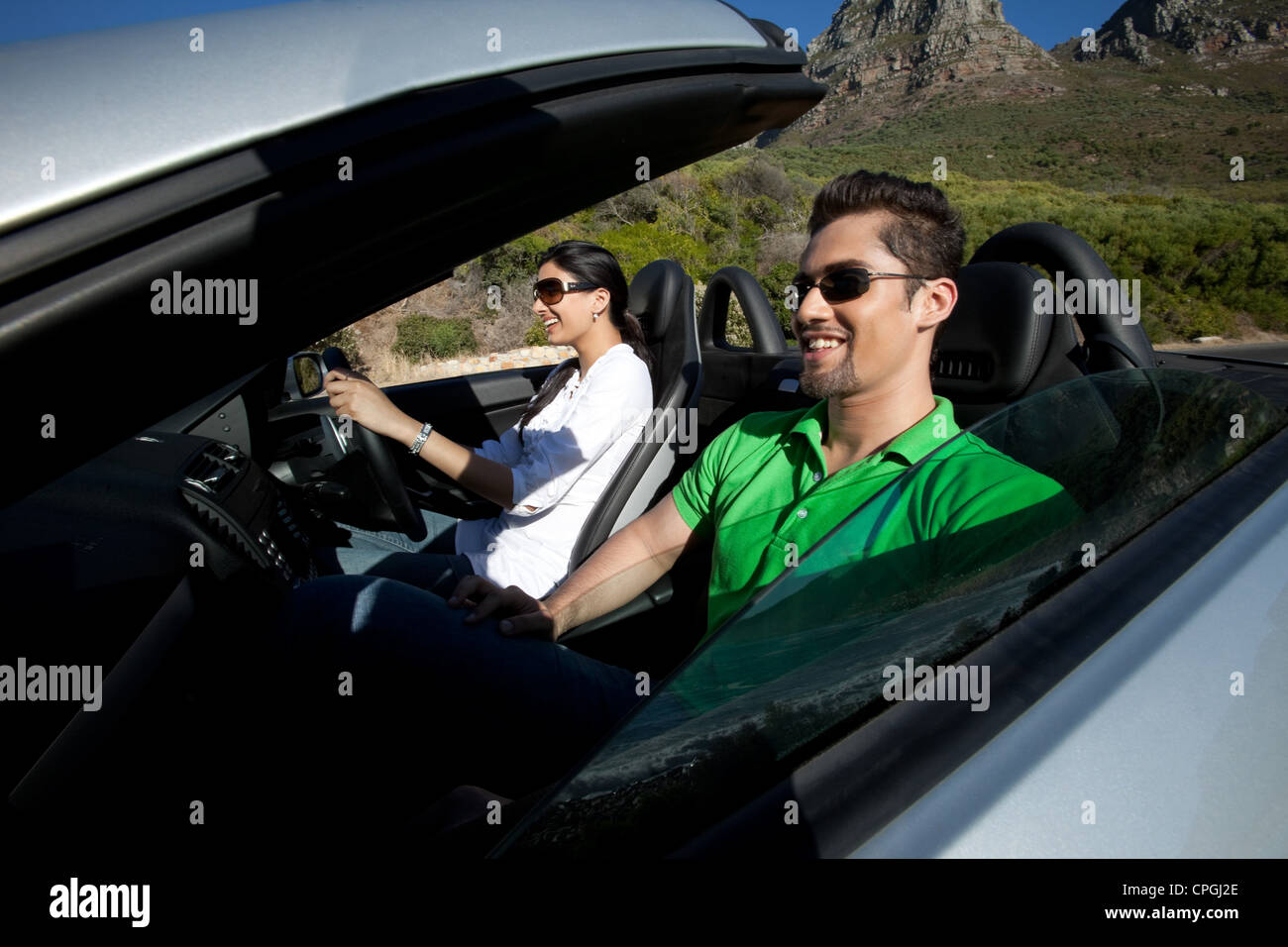 Couple riding in a convertible car, smiling Stock Photo - Alamy