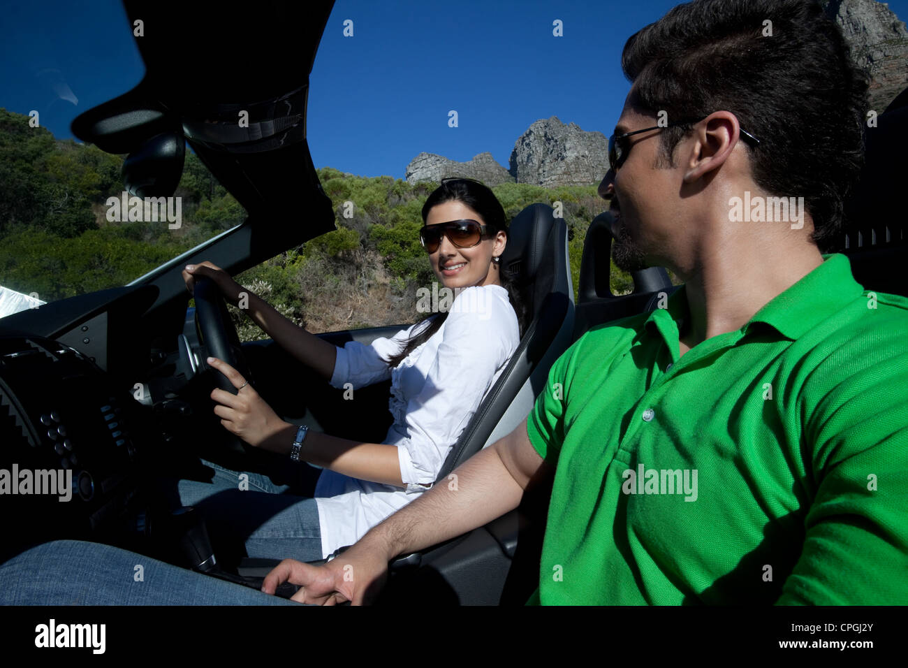 Couple riding in a convertible car, smiling Stock Photo - Alamy
