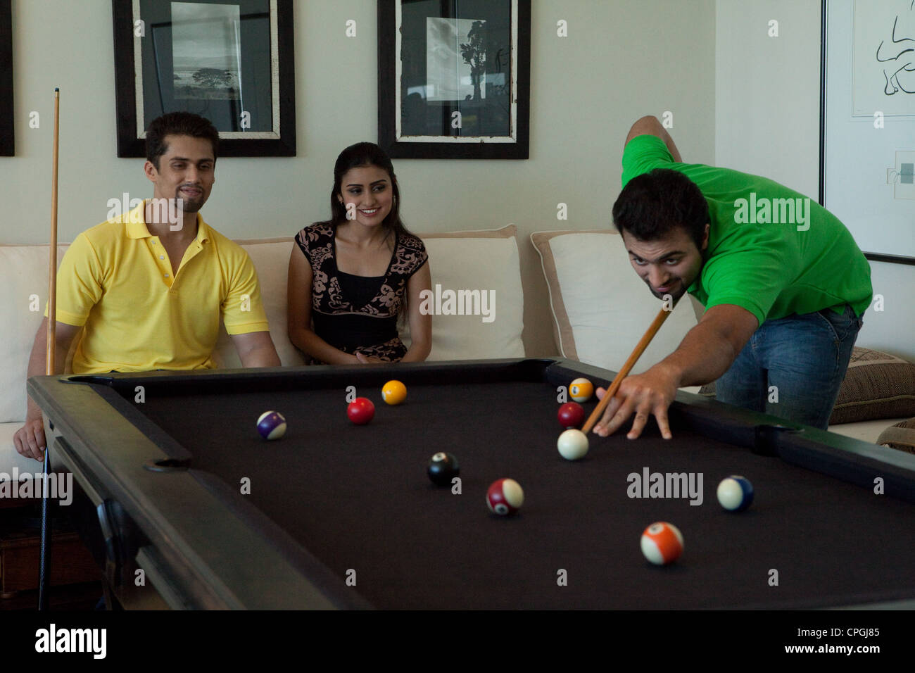 Friends playing billiard together Stock Photo - Alamy